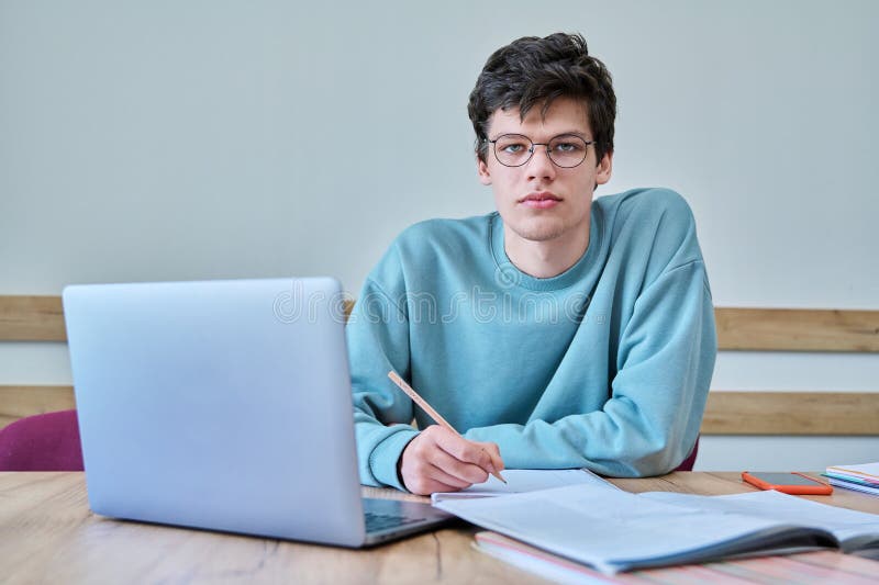 Young Guy College Student Sitting at Desk in Classroom, Using Laptop ...