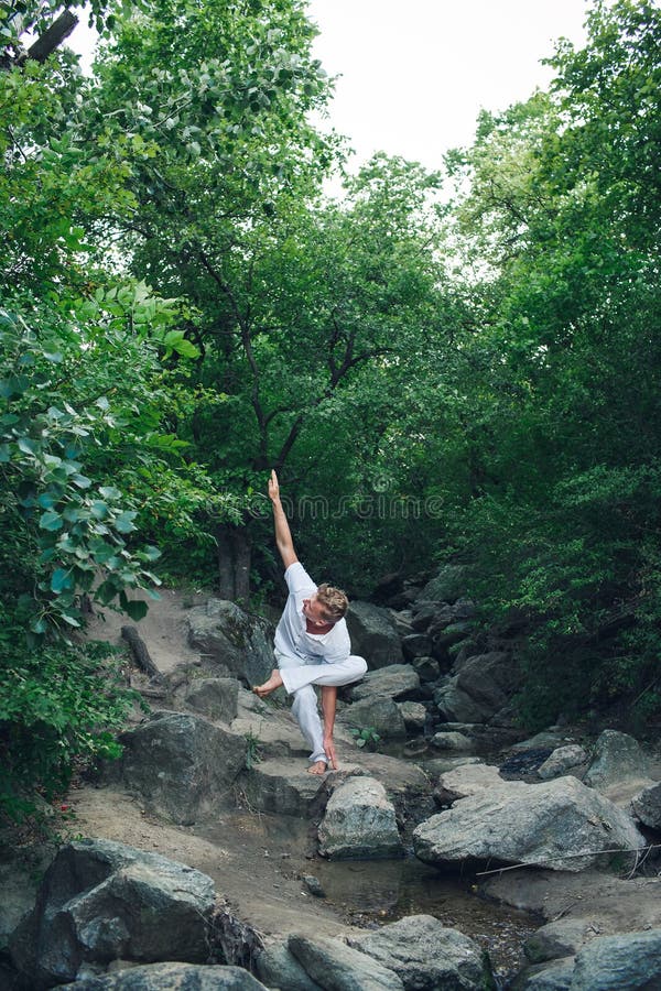 A Young Guy Does an Asana Standing on One Leg. a Man is Doing Yoga by ...