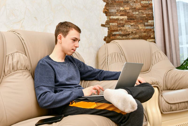 A Young Guy is Doing Projects at Home on a Laptop. the Concept O Stock ...
