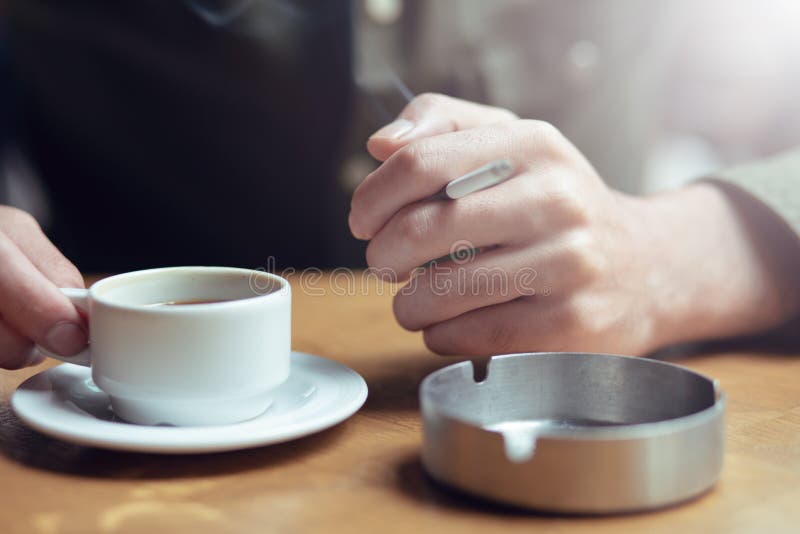 Drinks Coffee and Smokes a Cigarette in a Cafe Stock Photo - Image of ...