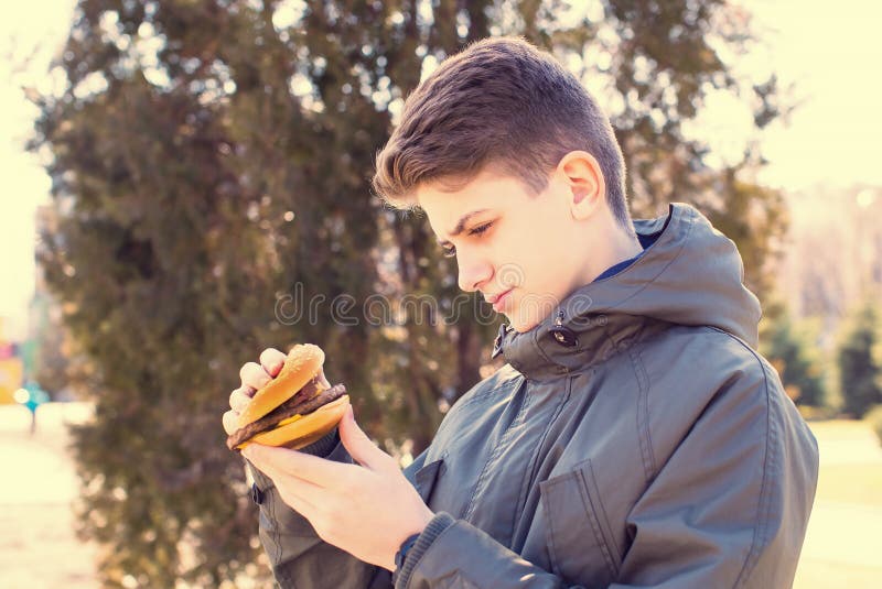 Young Guy Eating a Cheeseburger Stock Image - Image of beef ...