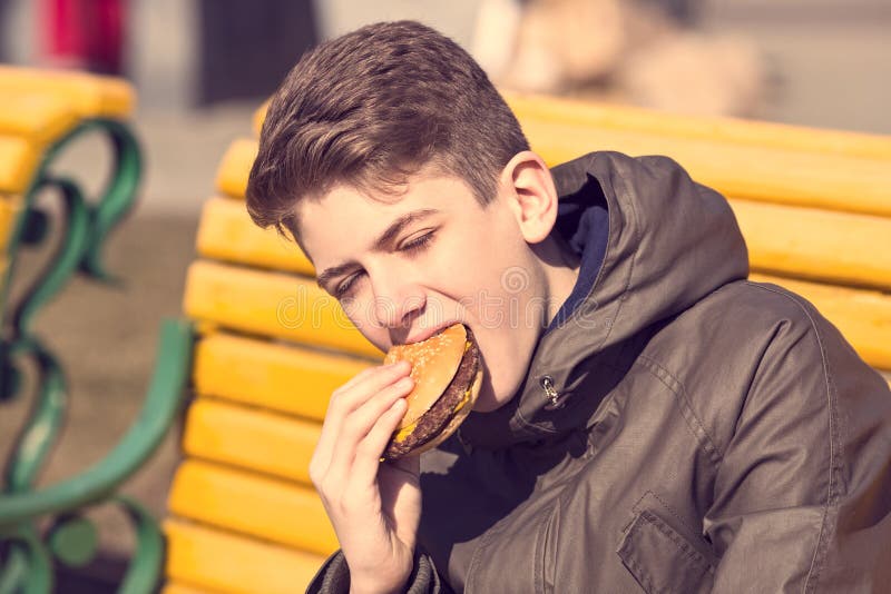 Young Guy Eating a Cheeseburger Stock Photo - Image of emotional, hold ...
