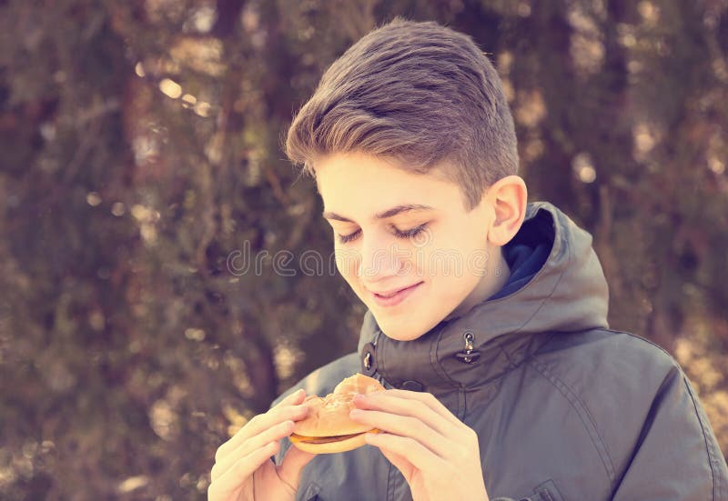 Young Guy Eating a Cheeseburger Stock Photo - Image of fatty ...