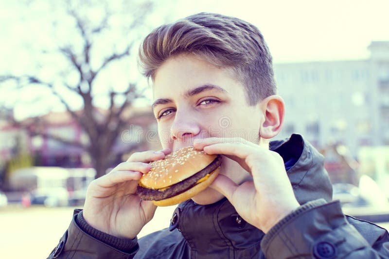 Young Guy Eating a Cheeseburger on the Nature Stock Image - Image of ...