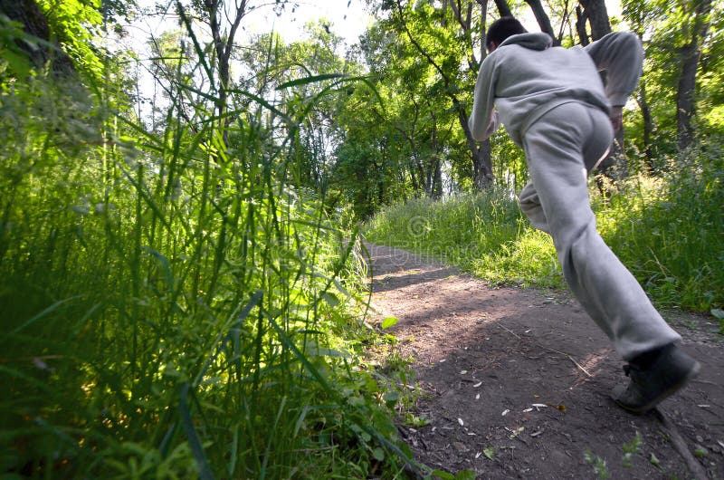 A Young Guy in a Gray Sports Suit Runs Along the Path among the Stock ...