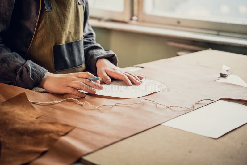 A Young Guy in a Leather Workshop Transfers a Pattern from Paper To ...