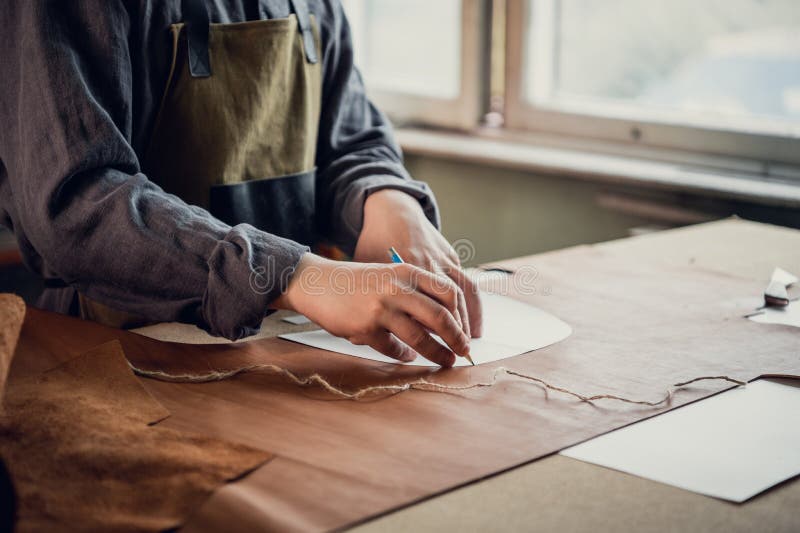 A Young Guy in a Leather Workshop Transfers a Pattern from Paper To ...