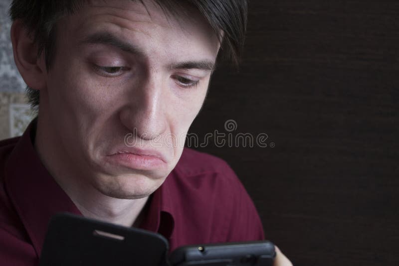 Young Guy Looking into Smartphone, Sad Face Stock Photo - Image of ...
