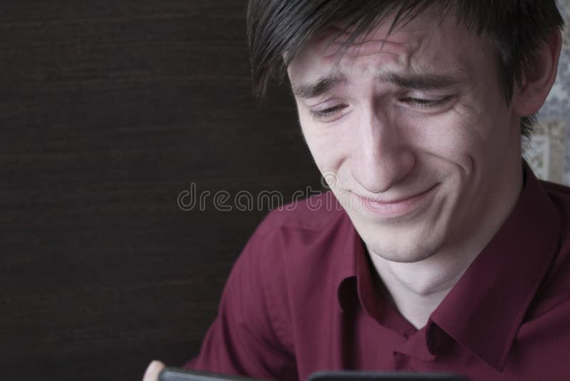 A Young Guy Looks into a Smartphone, a Bewildered Person Stock Image ...