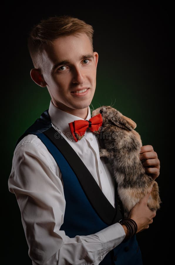 A Young Guy Magician Illusionist Holding a Hat with a Rabbit Stock ...