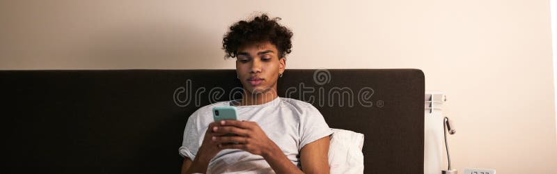 Young Guy with Piercing Chatting with Friends, Using Smartphone in His ...