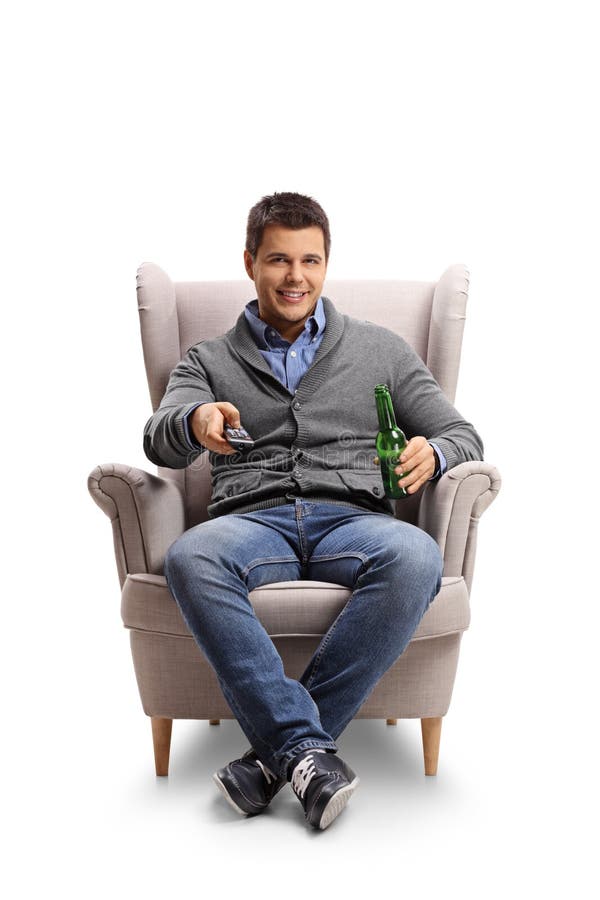 Young Guy With A Remote Control And A Beer Bottle Seated In An A Stock ...