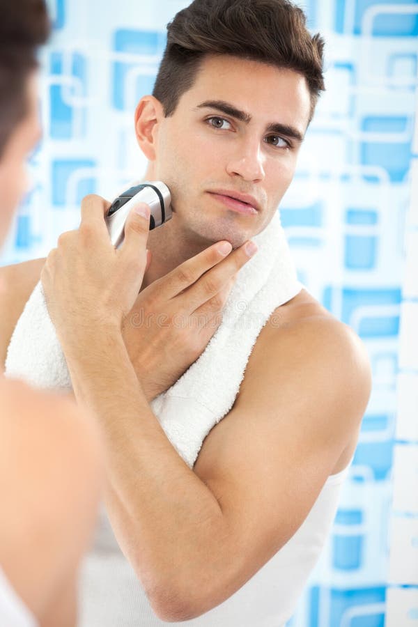 Young Guy Shaving His Beard Off with an Electric Shaver Stock Photo ...