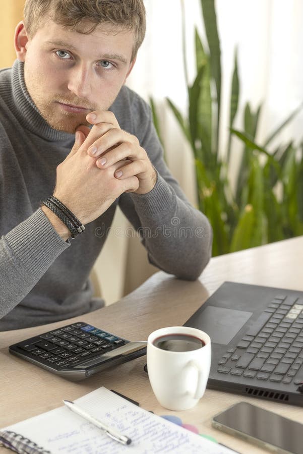 Young Guy Sitting at Table with Laptop and Coffee in Office. Stock ...