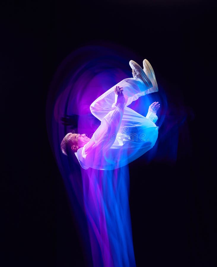 Young Guy in Sport Style Clothes in Motion, Doing Somersaults Against ...