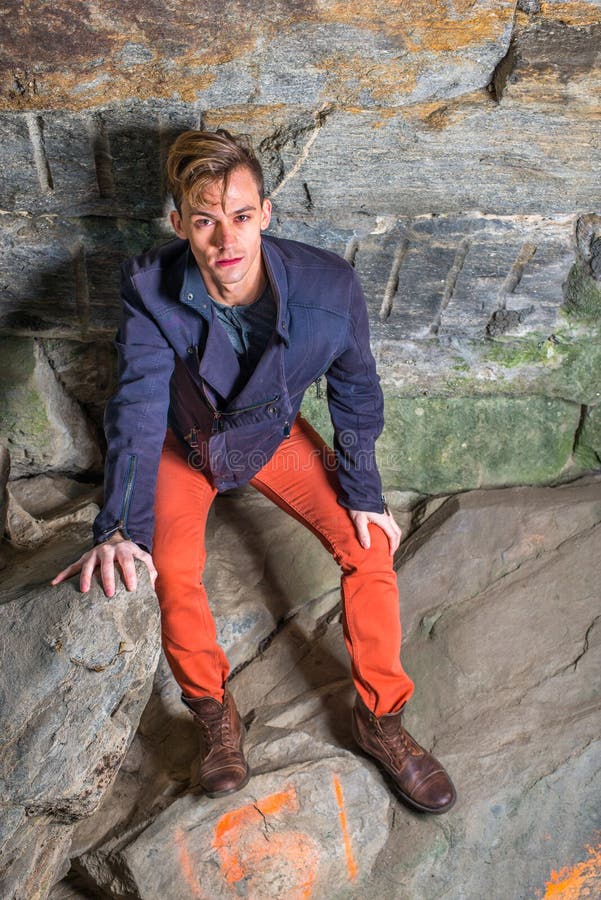 A Young Guy is Standing in a Cave of Rocks, Looking Up and Thinking ...