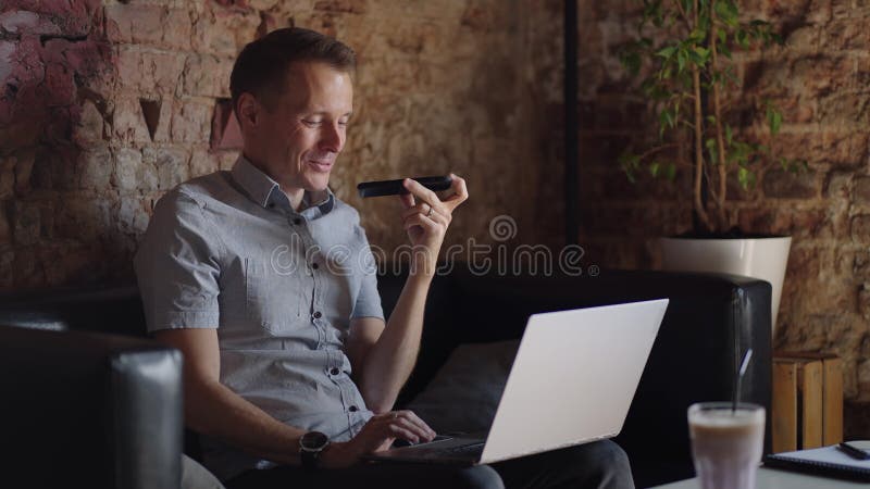 Young Guy Talking on Mobile Phone and Taking Notes, Using Voice ...
