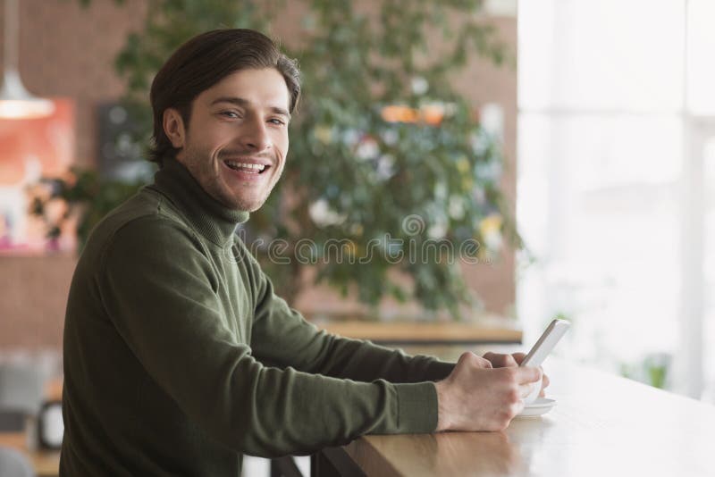 Young Guy Using Mobile Phone at Cafe, Smiling at Camera Stock Image ...