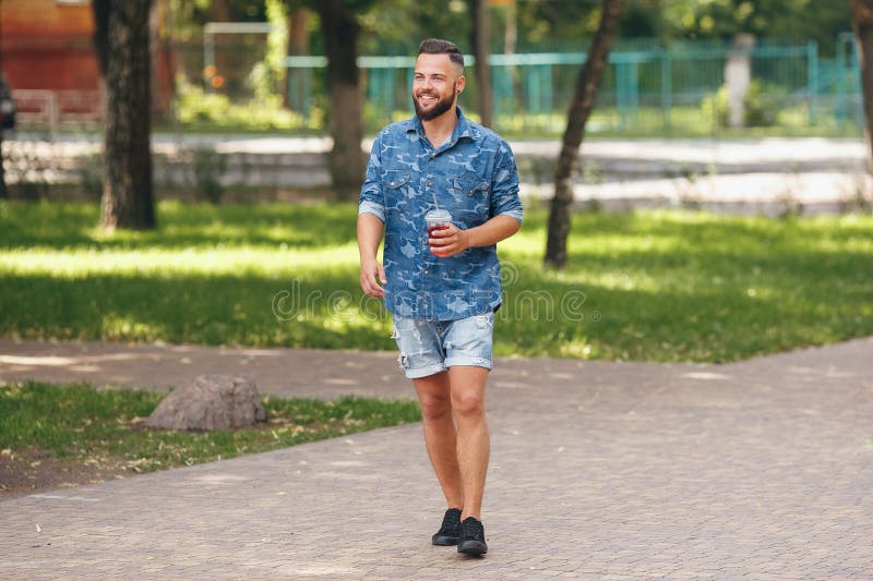 A Young Guy Walking in the Park with Lemonade in the Spring. Spring Day ...