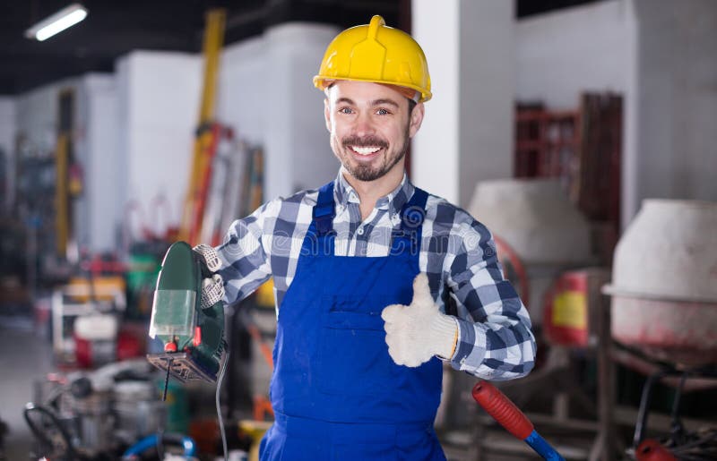 Young Guy Worker is Using Power Jigsaw for Construction Work Stock ...