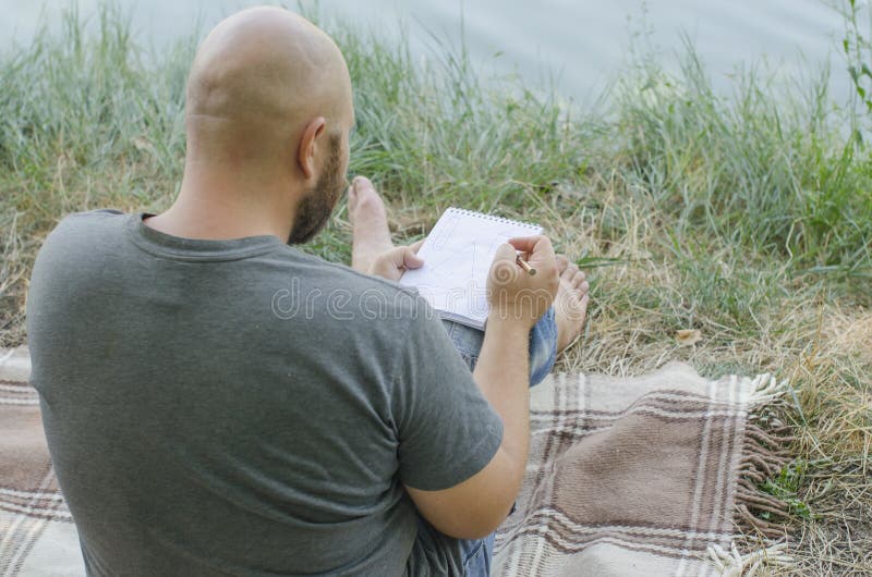 The Young Guy Writes in a Notebook Stock Photo - Image of career ...
