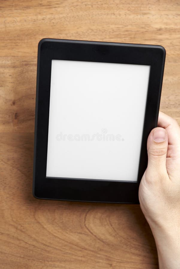 Young Hand Holding an Electronic Reader with Blank Screen on a Wooden ...