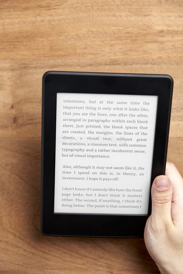 Young Hand Holding an Electronic Reader with Text on the Screen on a ...