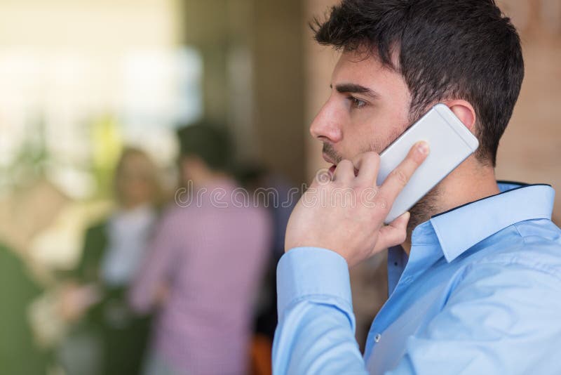 A Young, Handsome Business Man at the Office Building on Phone Stock ...