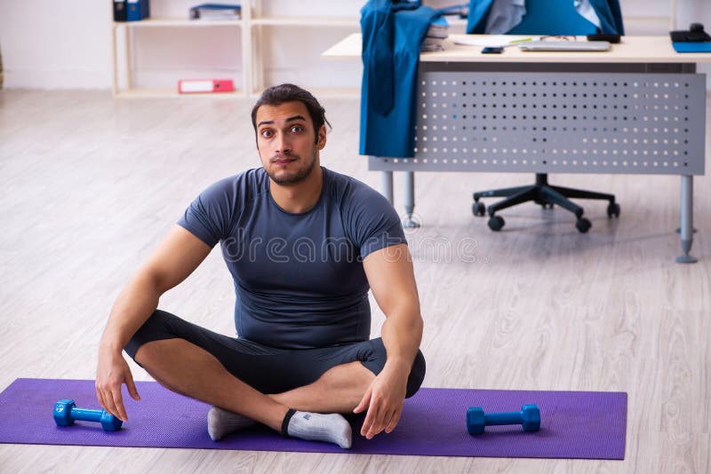 Young Handsome Employee Doing Sport Exercises in the Office Stock Photo ...