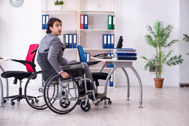 The Young Handsome Employee in Wheelchair Working in the Office Stock ...