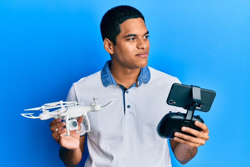 Young Handsome Hispanic Man Using Drone Holding Remote Control Smiling ...