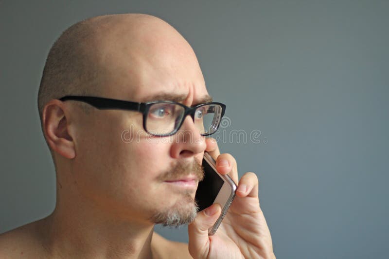 Young Handsome Man In Black Glasses Is Talking On The Phone Closeup
