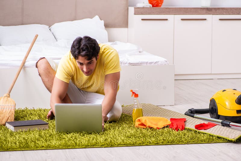 Young Handsome Man Cleaning the Bedroom and Sitting at the Compu Stock ...