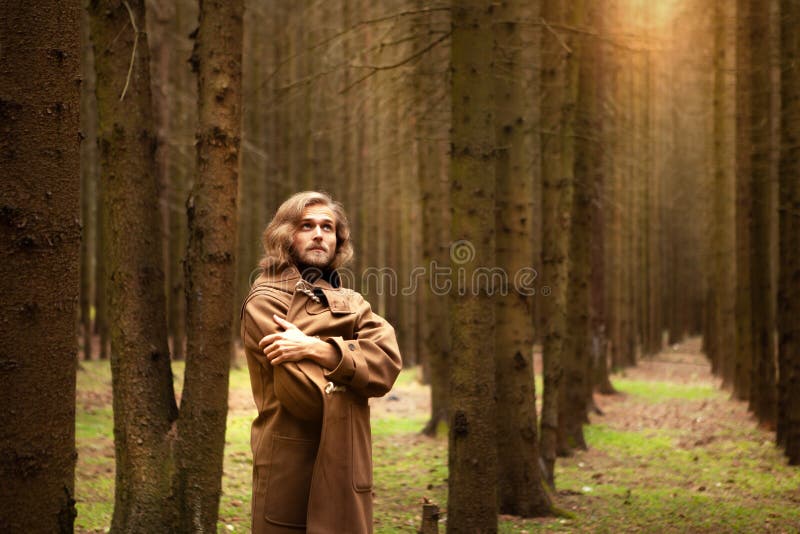 A Young Handsome Man in a Coat, in a Dense Wild Forest. Stock Photo ...