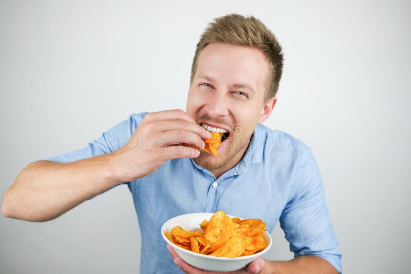 Young Handsome Man Eats Chips on Isolated White Background Stock Photo ...