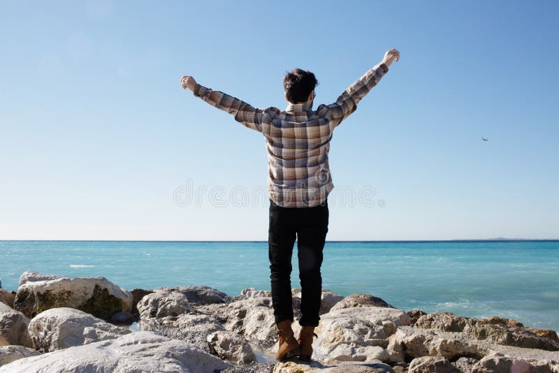 Young Handsome Man Enjoying a Sunny Weather on the Beach. Back Side ...