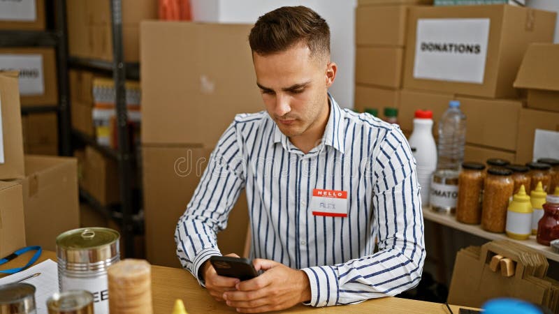 A Young Handsome Man Named Alex Using a Smartphone in a Warehouse with ...