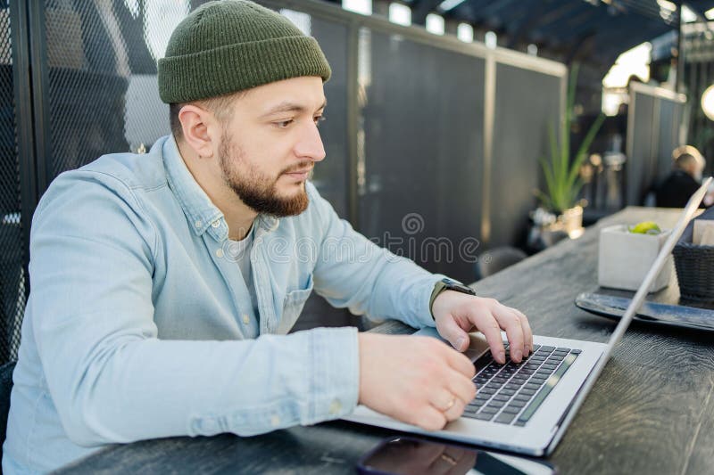 Young Handsome Man Sitting in Cafe, Typing and Using Laptop. Handsome ...