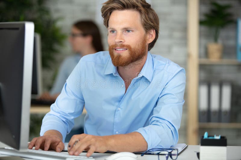 Young Handsome Man Sitting at Desk in Office Stock Image - Image of ...