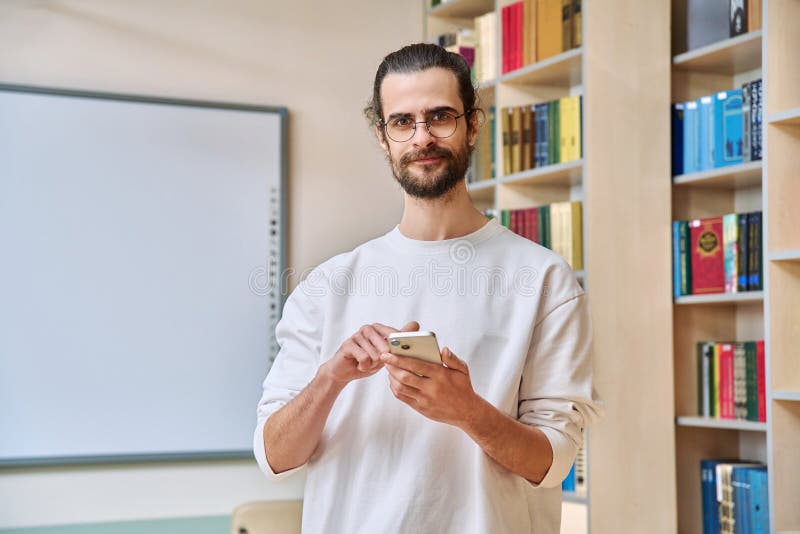 Young Handsome Man with Smartphone Looking at Camera Inside Library ...