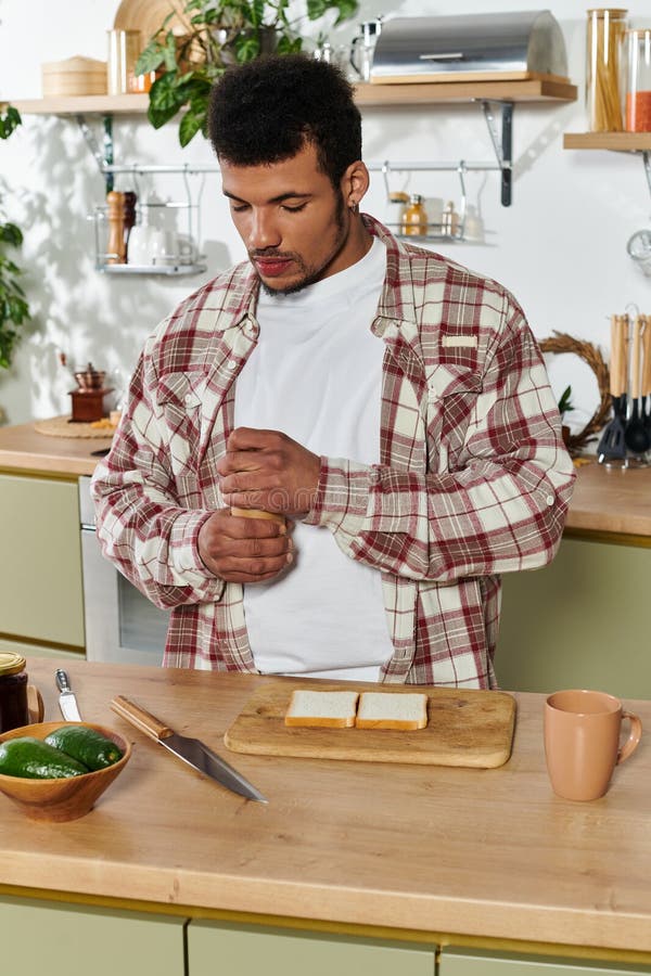 Young Man Prepares Sandwich in a Stock Image - Image of focused ...