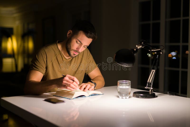 Young Handsome Man Studying at Home, Reading a Book at Night Stock ...