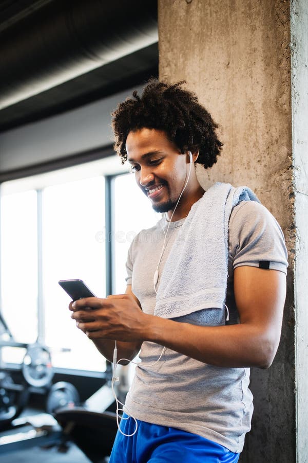 Young Handsome Man Using Phone while Having Exercise Break in Gym Stock ...