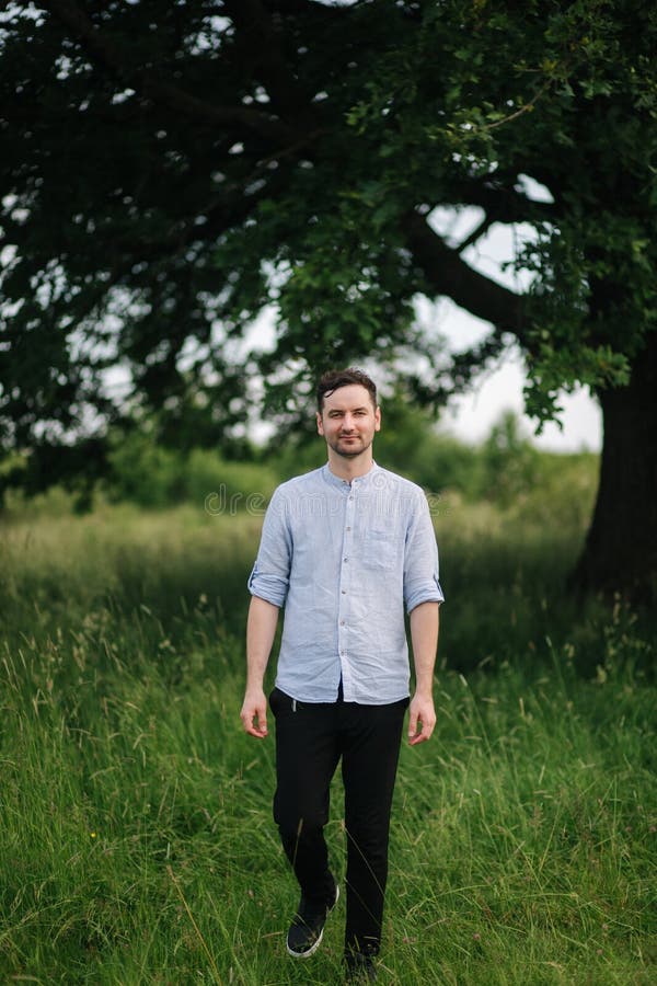 Young Handsome Man Walking in Front of Big Tree. Portrait of Man in ...