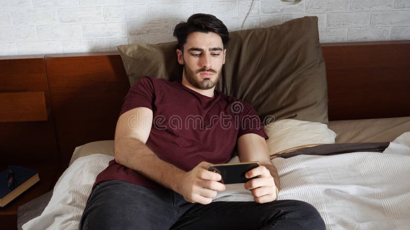 Young Man Watching Movie on Cellphone in Bed Stock Image - Image of ... Young Man Watching Movie on Cellphone in Bed Stock Image - Image of ...