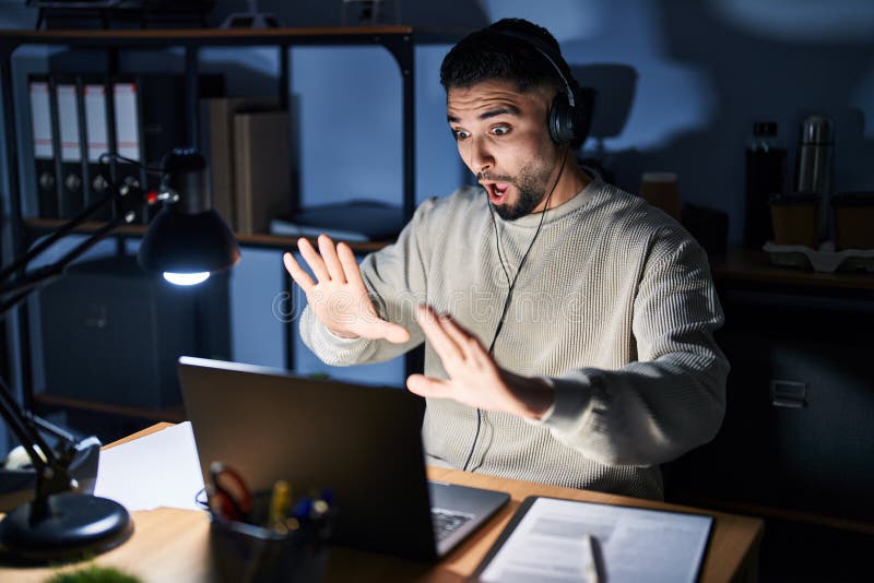 Young Handsome Man Working Using Computer Laptop at Night Afraid and ...