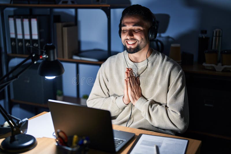 Young Handsome Man Working Using Computer Laptop at Night Praying with ...