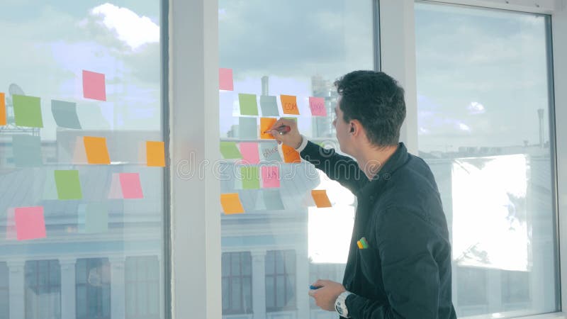 Young Handsome Man Writing on Sticky Notes on Panoramic Window in ...