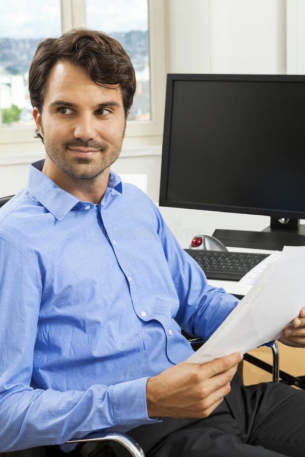 Young Handsome Manager Sitting At His Desk In The Office Stock Photo ...