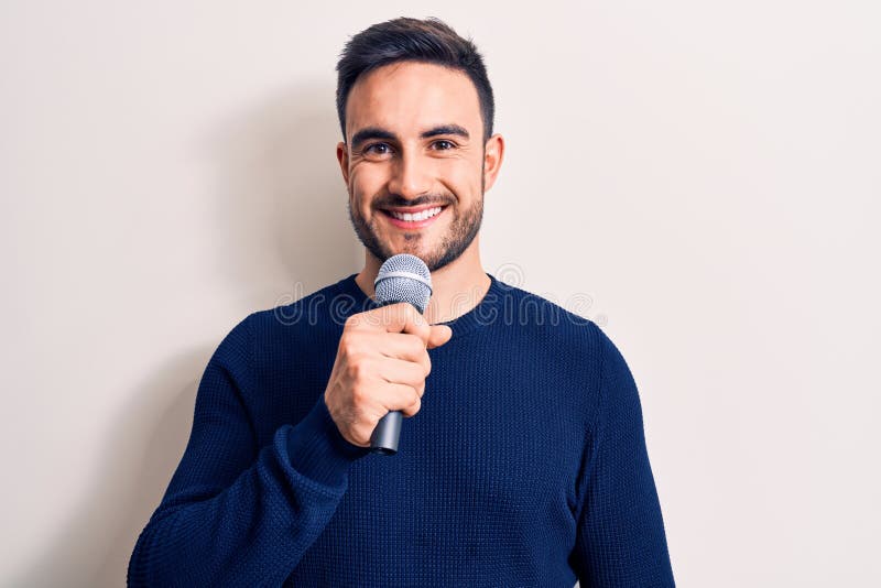 Positive Singer is Holding Microphone in Hands. he is Looking at Camera ...